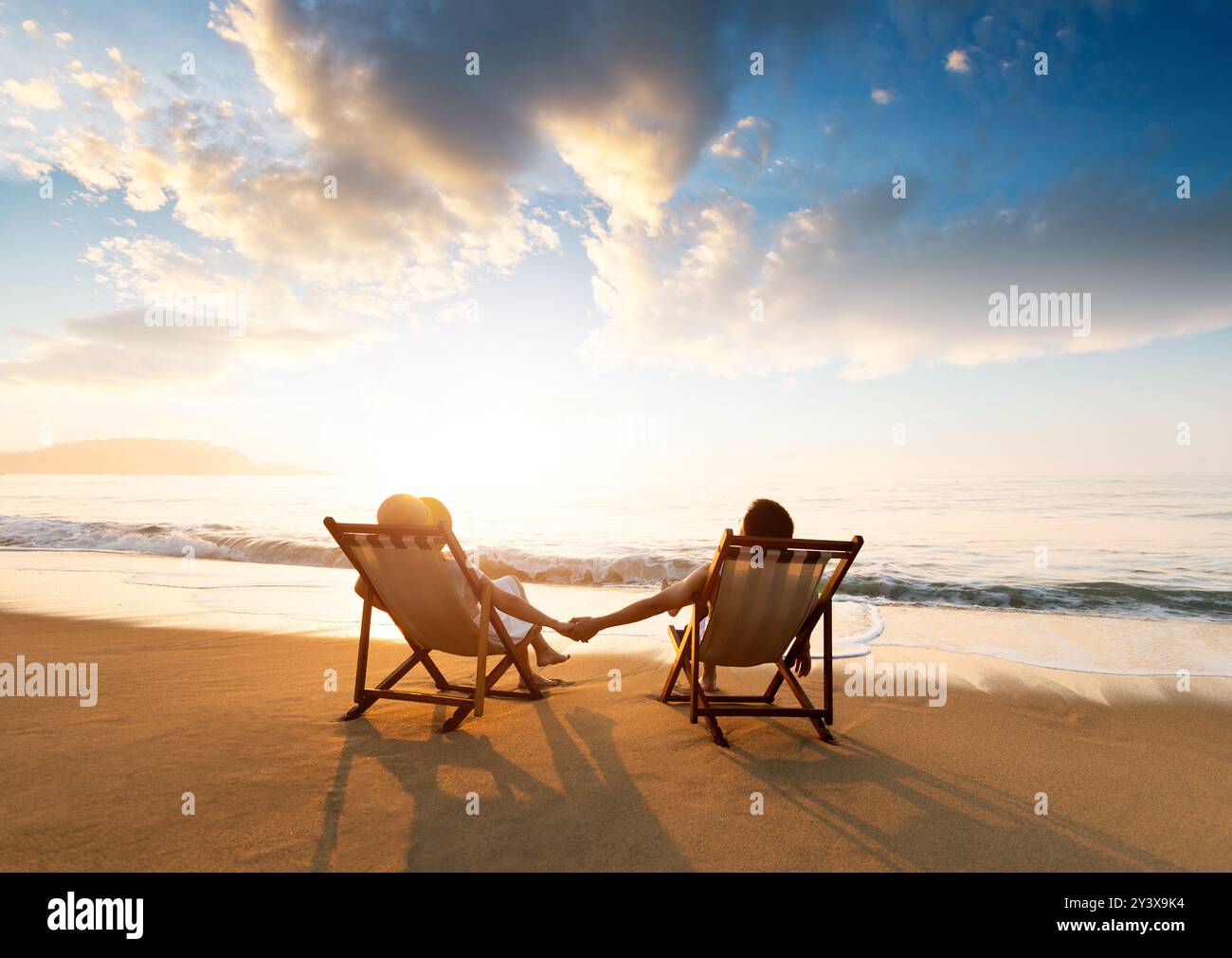 Young couple sunbathing on beach chair Stock Photo - Alamy