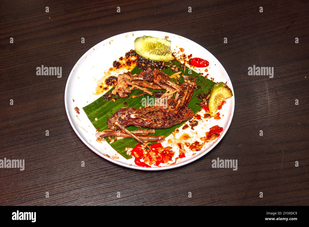 Food leftovers on white plate. Empty dishes scraps of chicken bones or ...