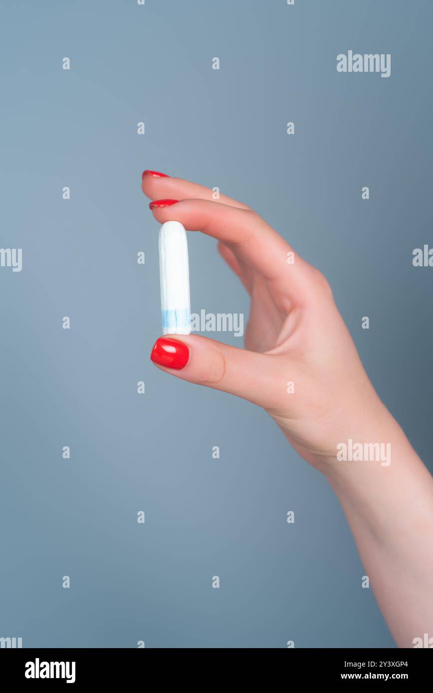 Hand holding menstruation tampon. Womens menstrual cramps. Feminine ...