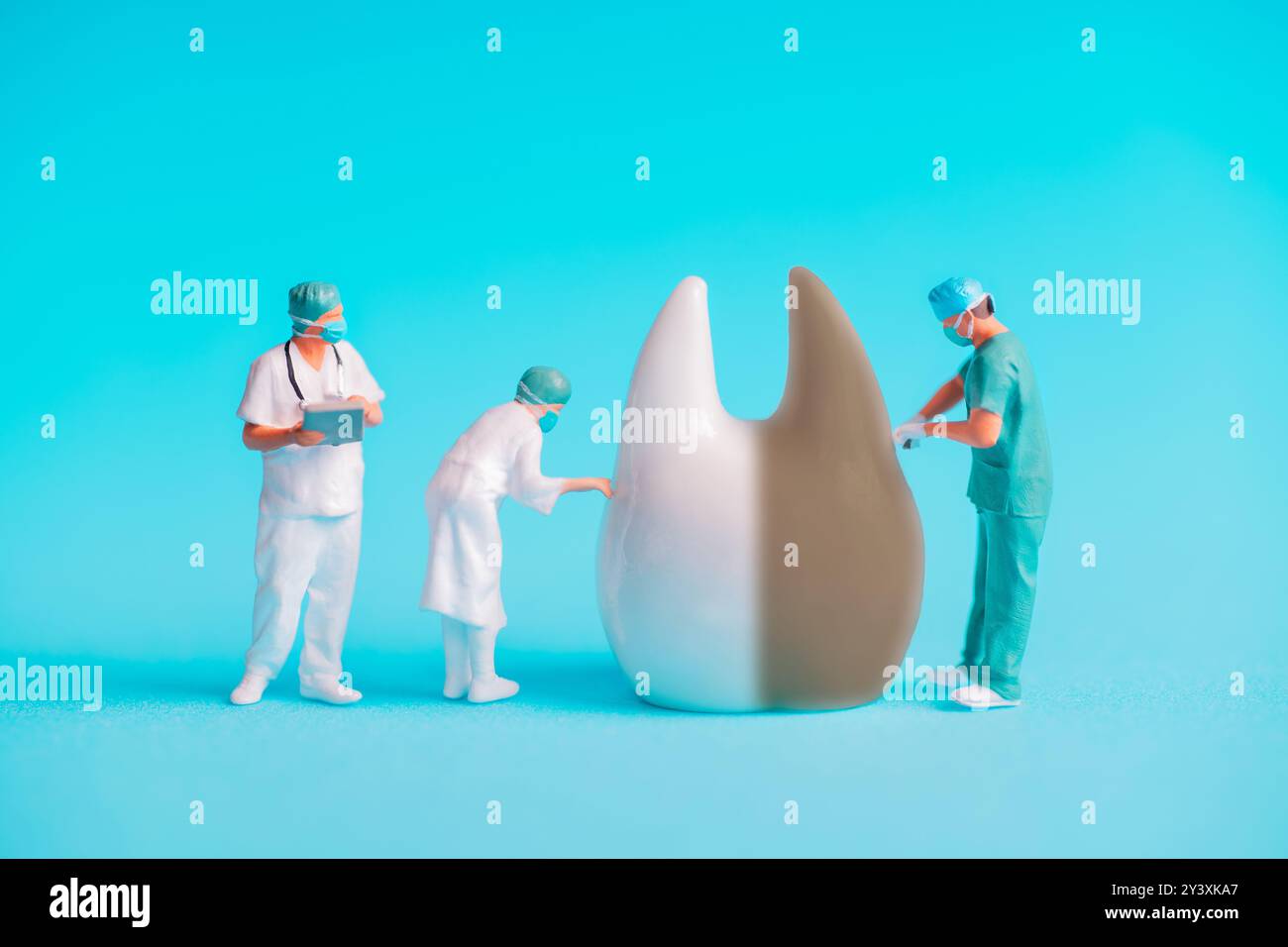 Miniature dental professionals figurines conducting a procedure on an ...