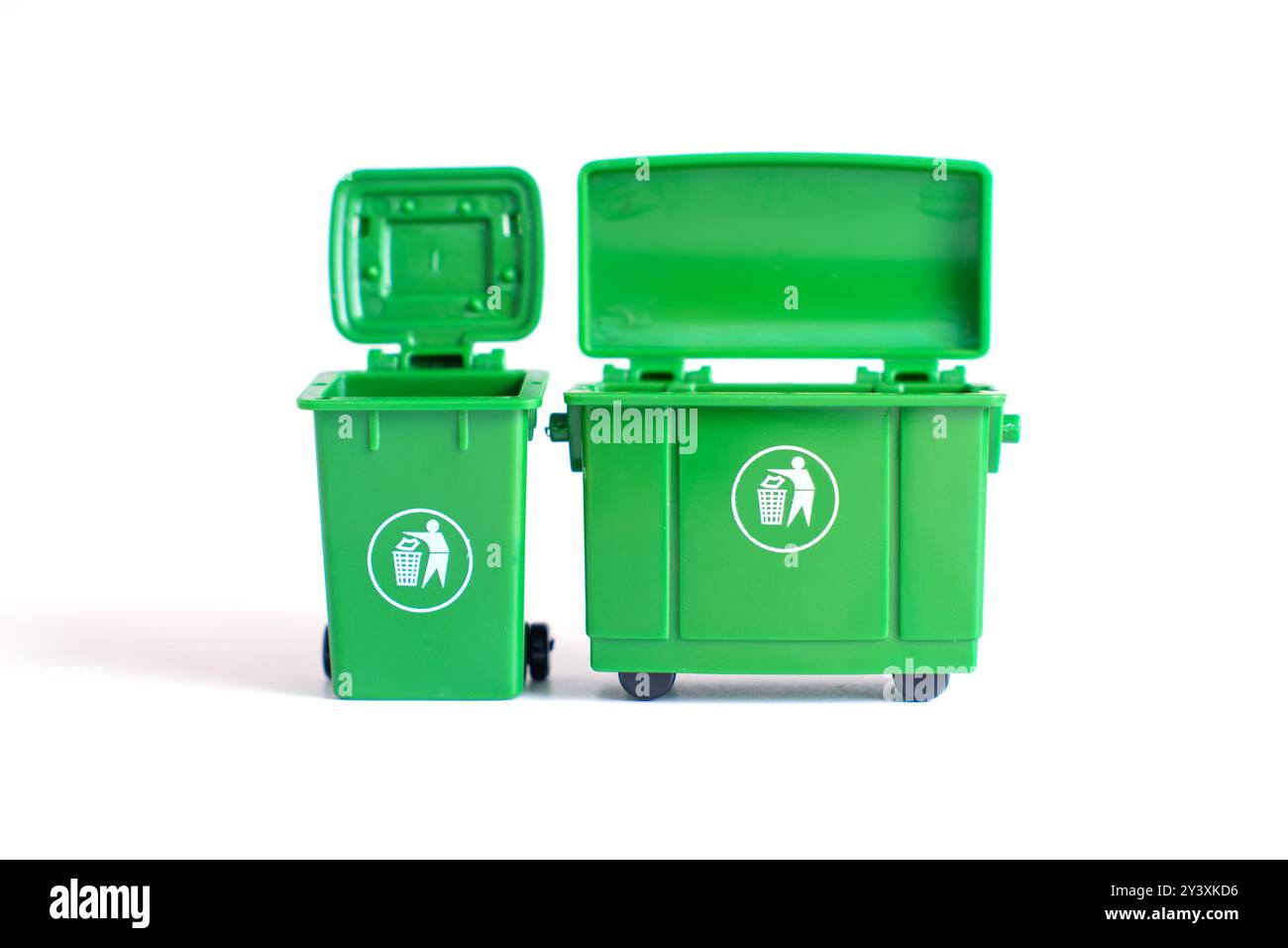 Two miniature green trash bins isolated on a clean white background ...