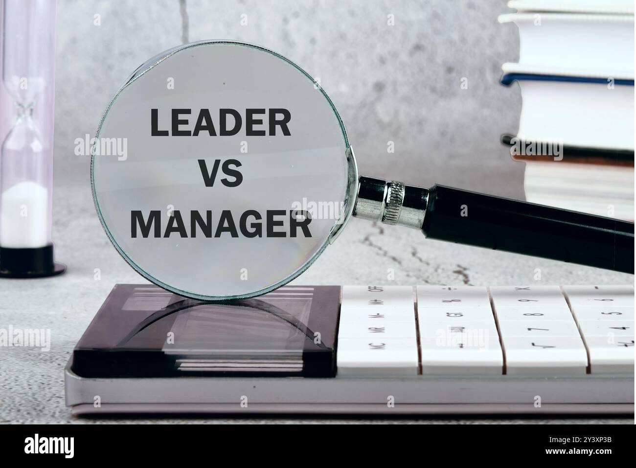 Leader vs manager is shown on the background through a magnifying gla ...