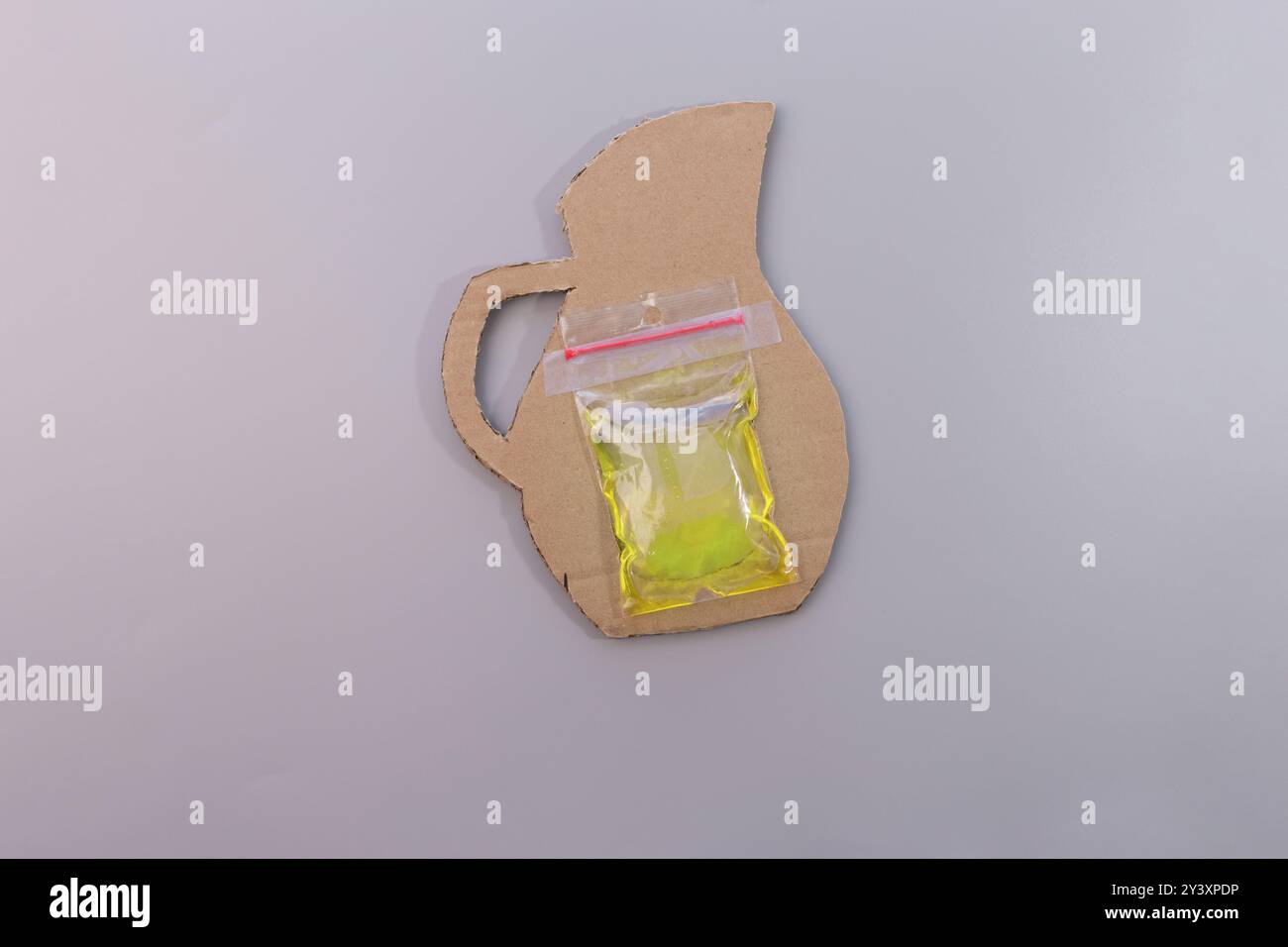 a freezer bag containing yellow liquid is taped to a cardboard piece of ...
