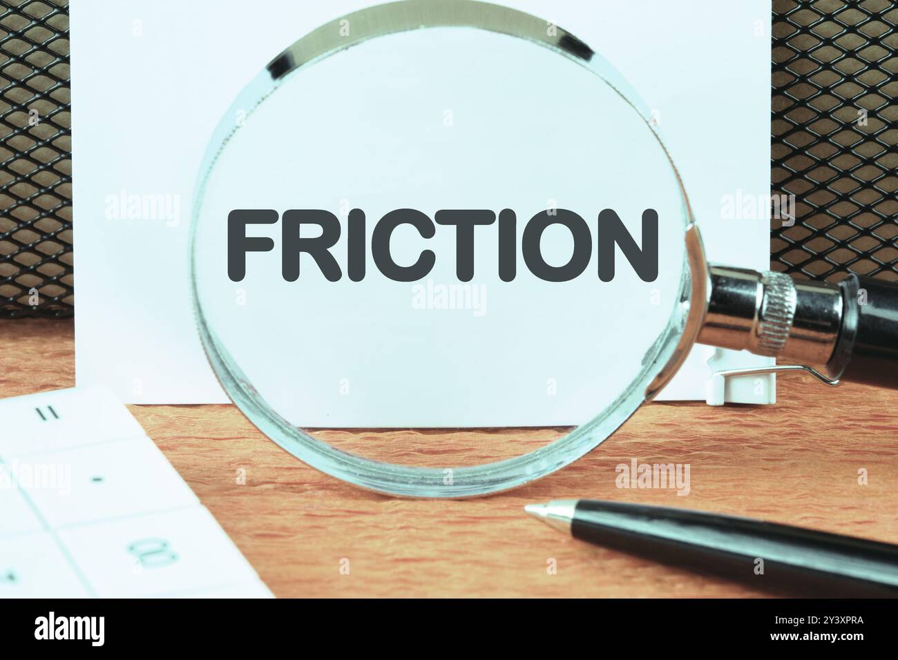 Friction concept. Friction word on a white sheet through a magnifying ...