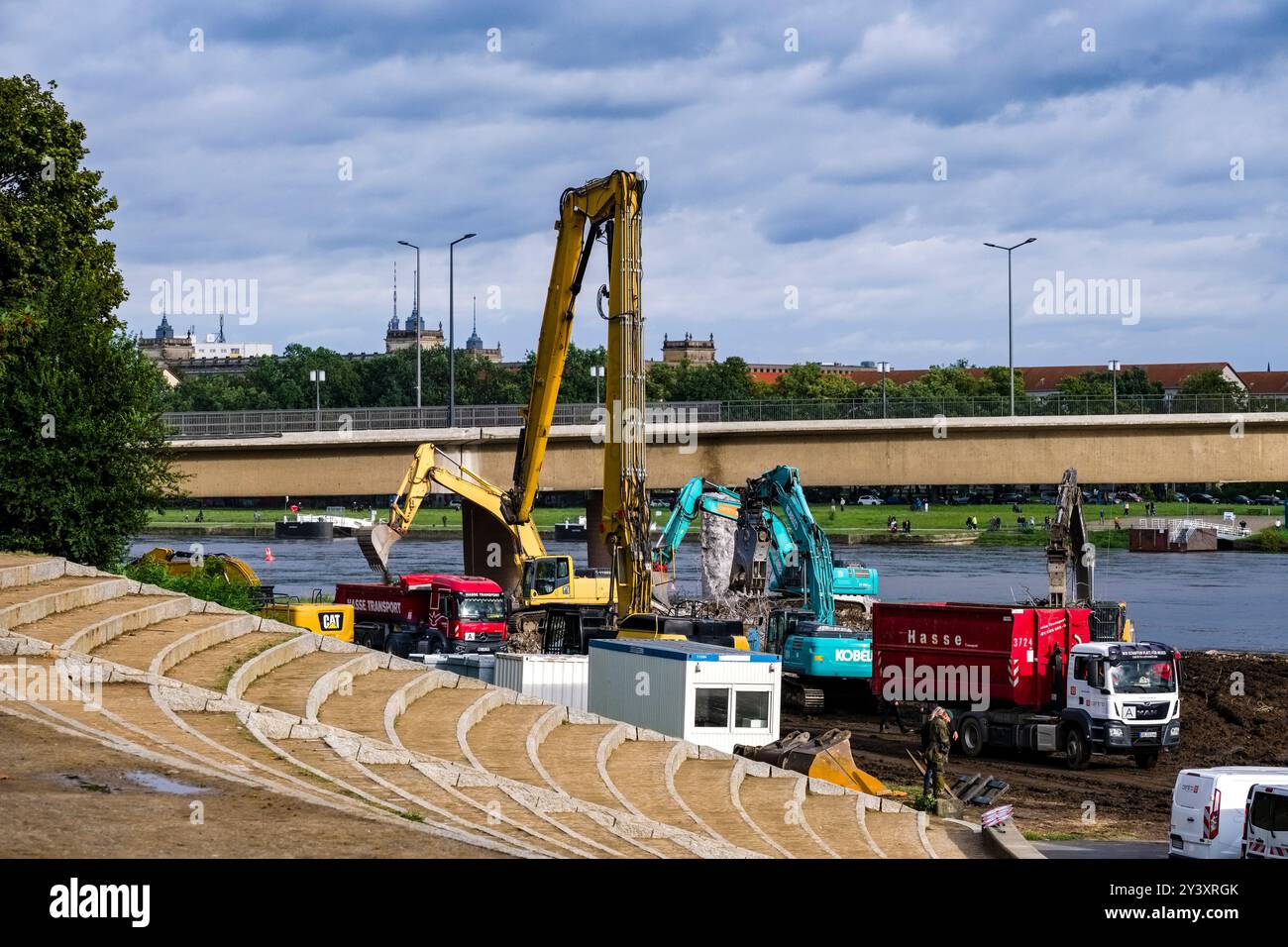 Excavators and trucks on the demolition site of the blasted section of ...