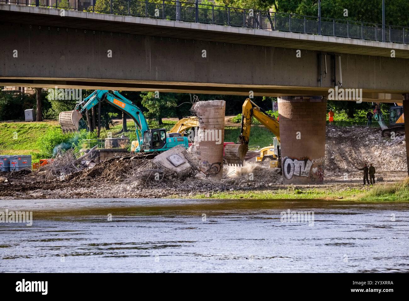 Excavators working on the demolition site of the blasted section of the ...