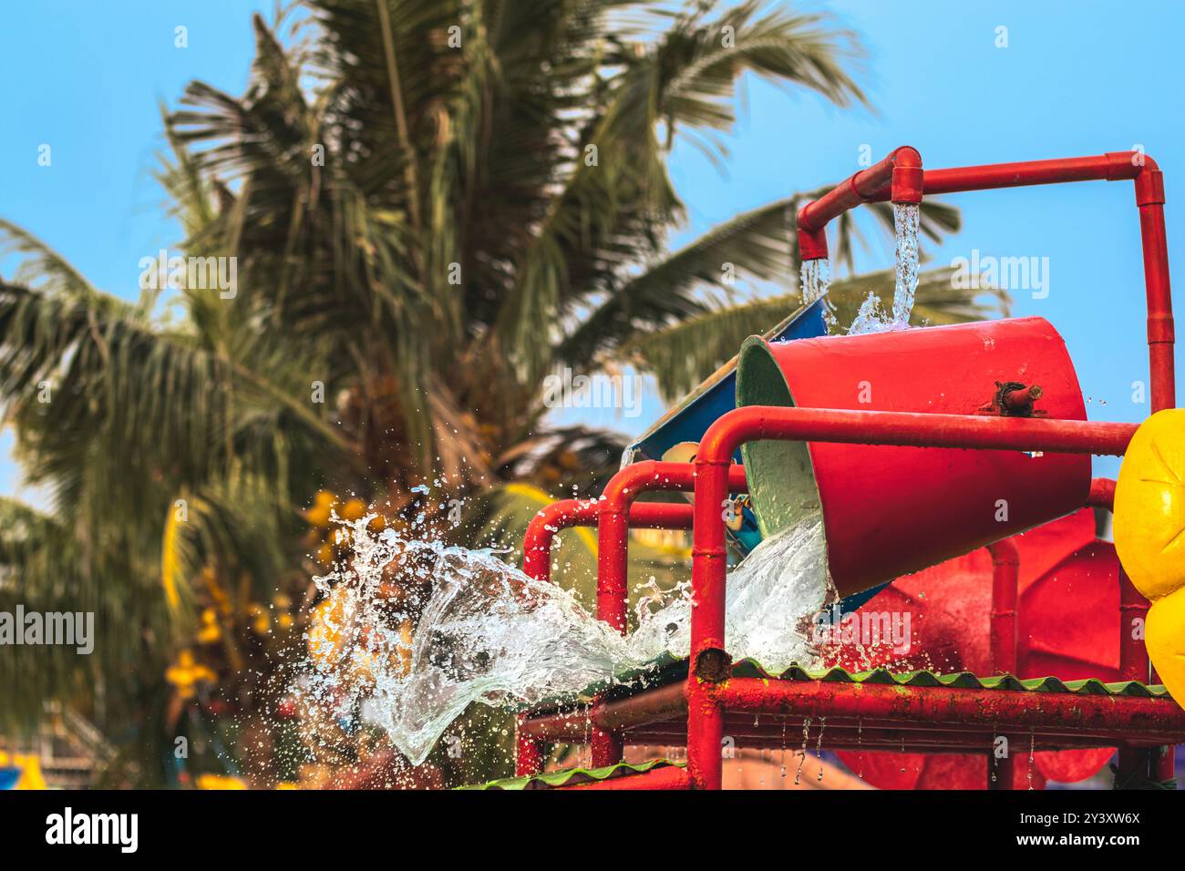 Water spills on the water bucket attraction in water park. Water splash ...