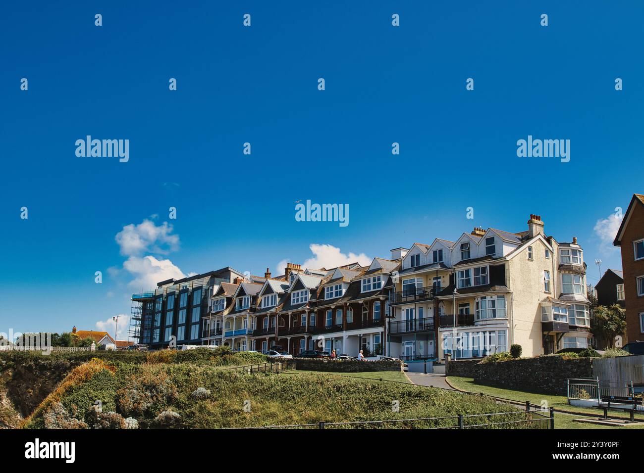 A row of charming seaside houses with balconies, set against a bright ...