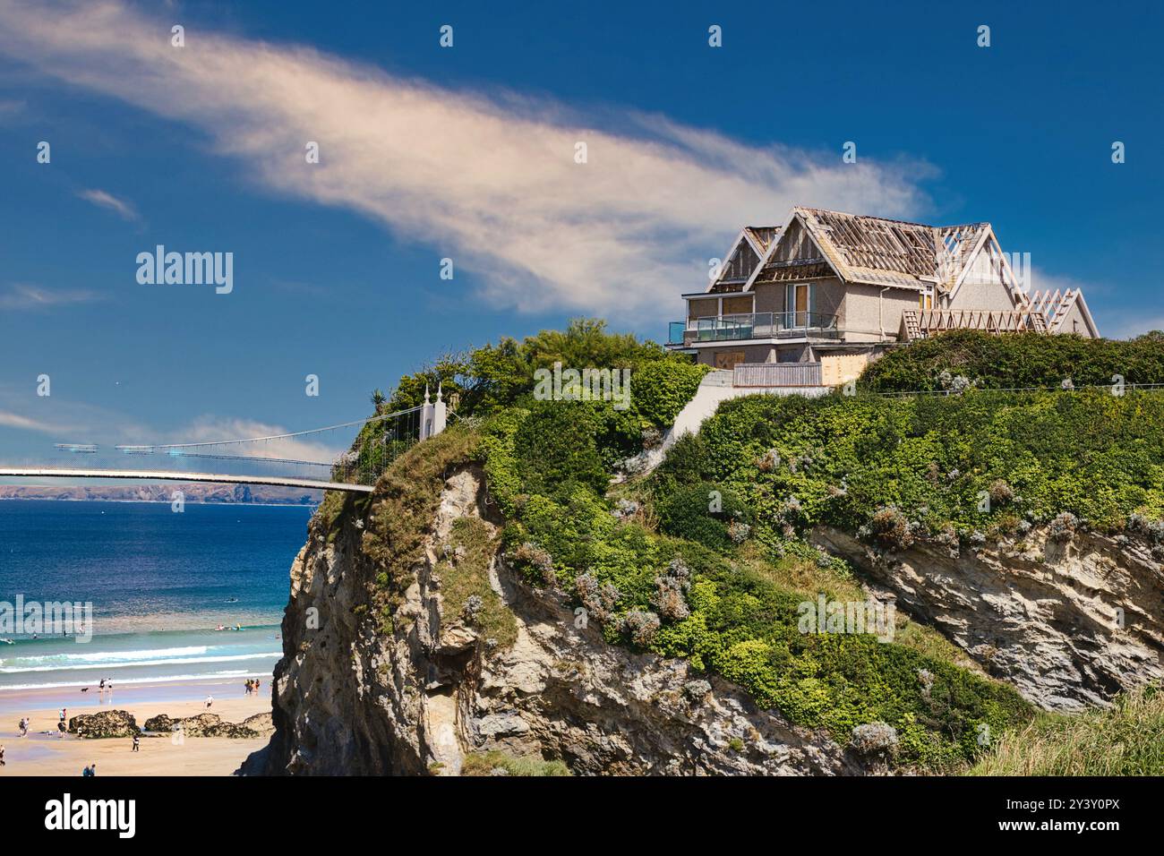A stunning coastal view featuring a modern house perched on a cliff ...