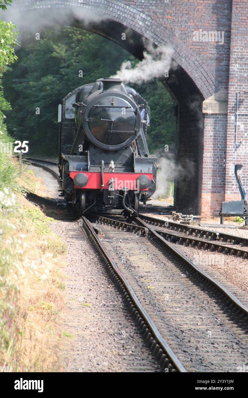 An Old Steam Train Engine Passing Under a Railway Bridge Stock Photo ...