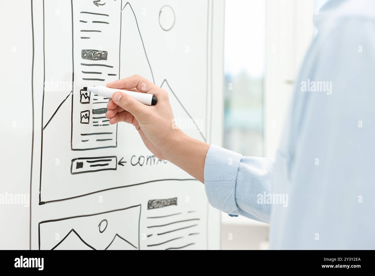 Developing UI design. Man drawing website wireframe on whiteboard ...