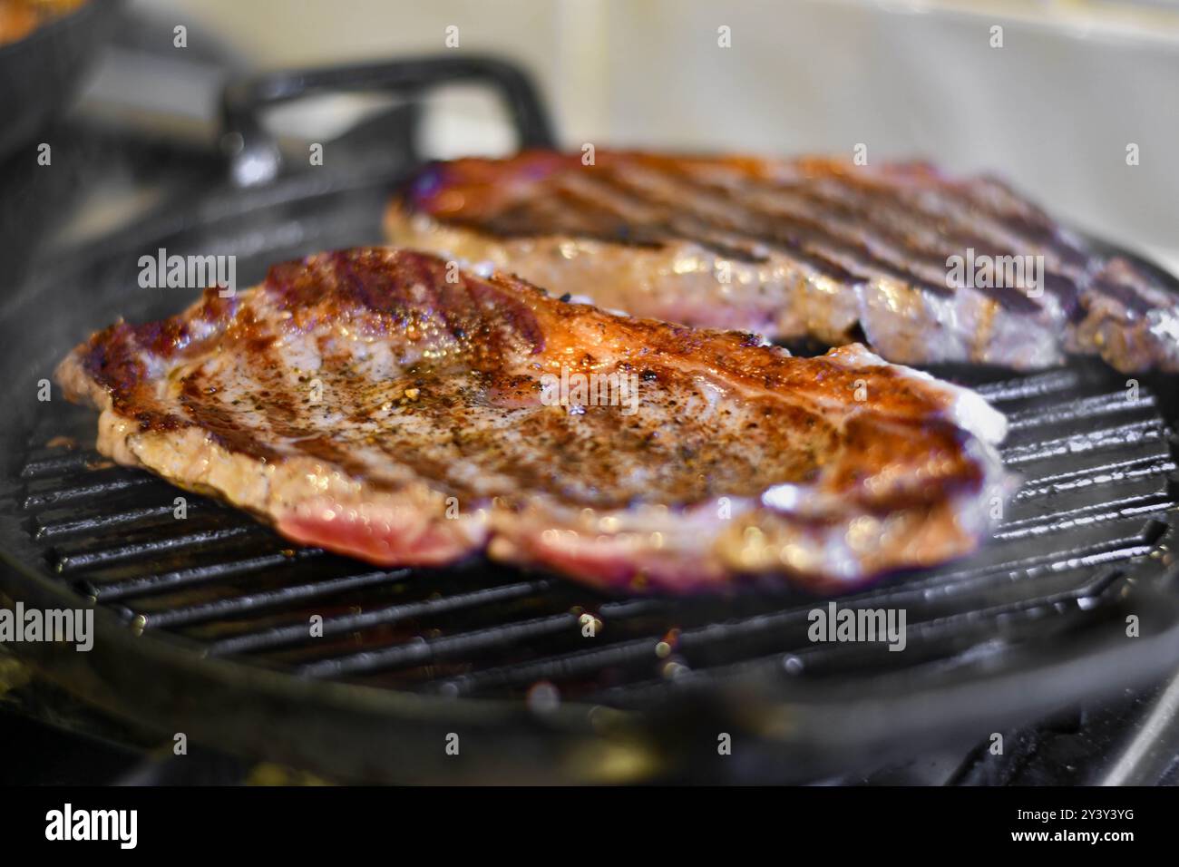 beef stake on a griddle hot plate pan Stock Photo - Alamy