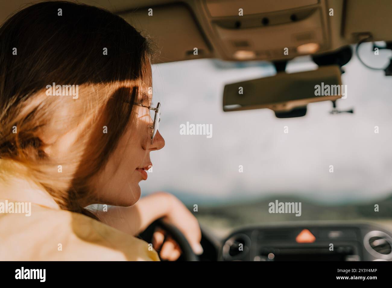 Young Woman Driving a Car with Sunlit Hair Stock Photo - Alamy