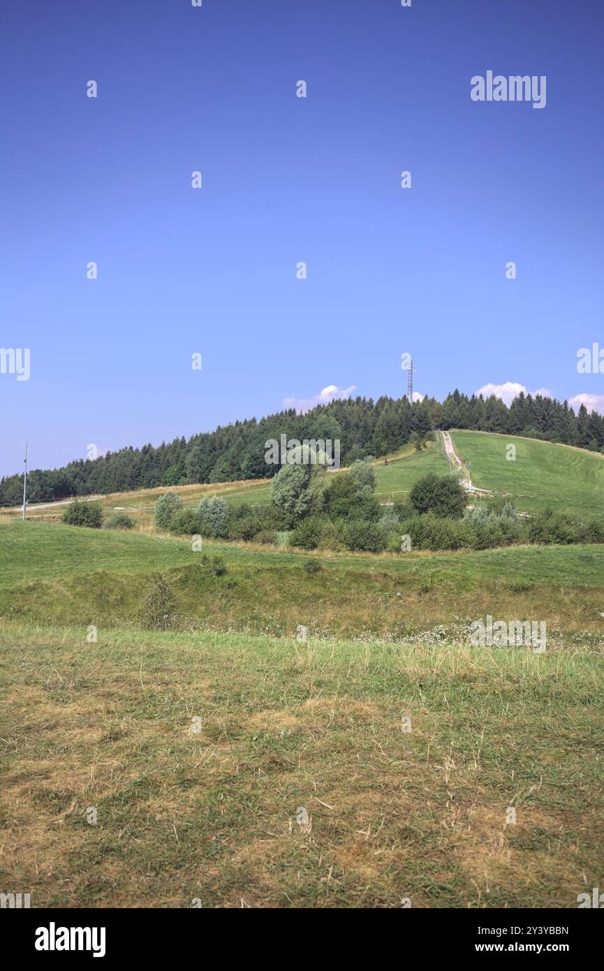 Small plateau on a mountain peak with groves and antennae on the peaks ...