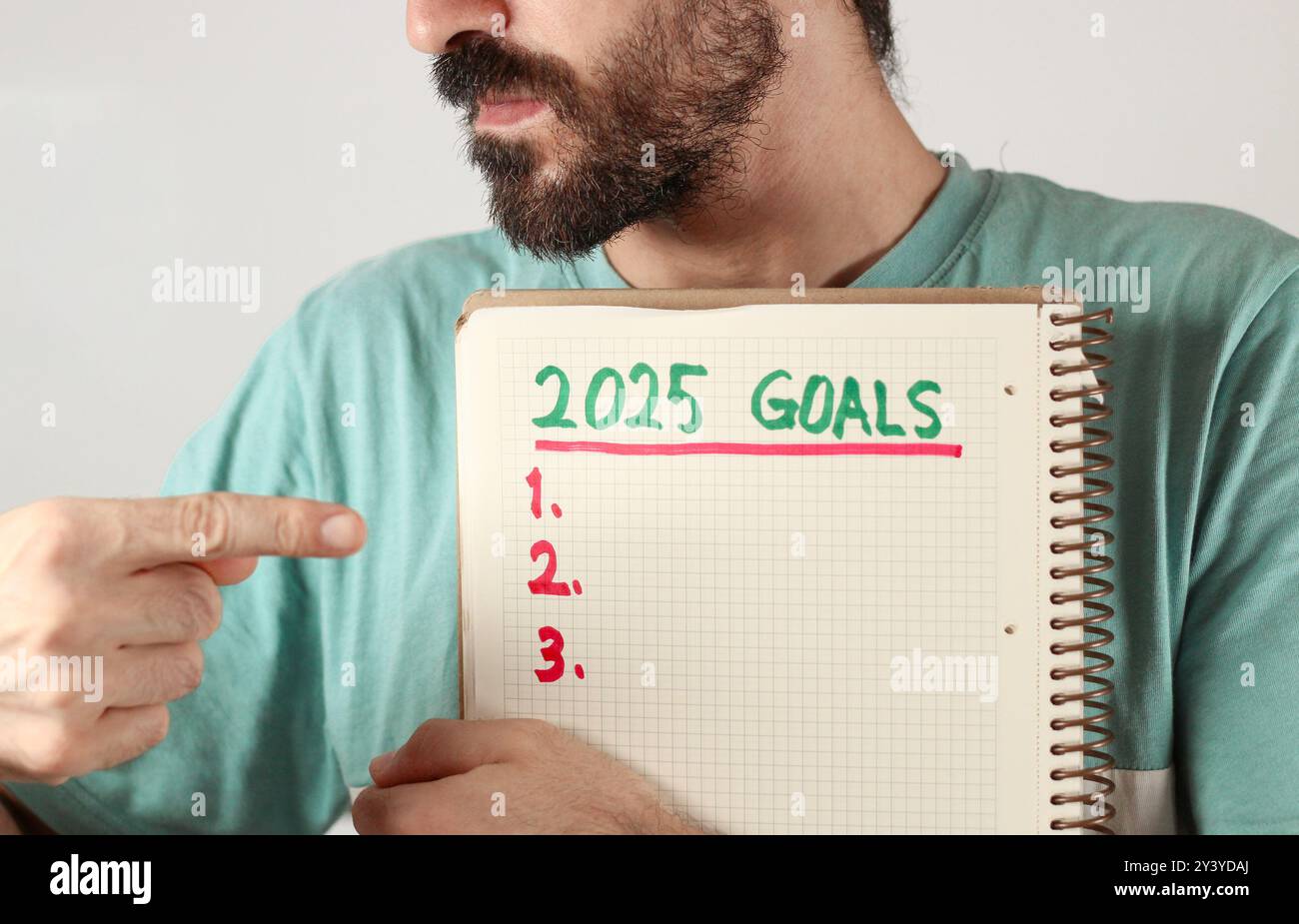A handsome caucasian men show his goals for 2025 years. Three goals for ...