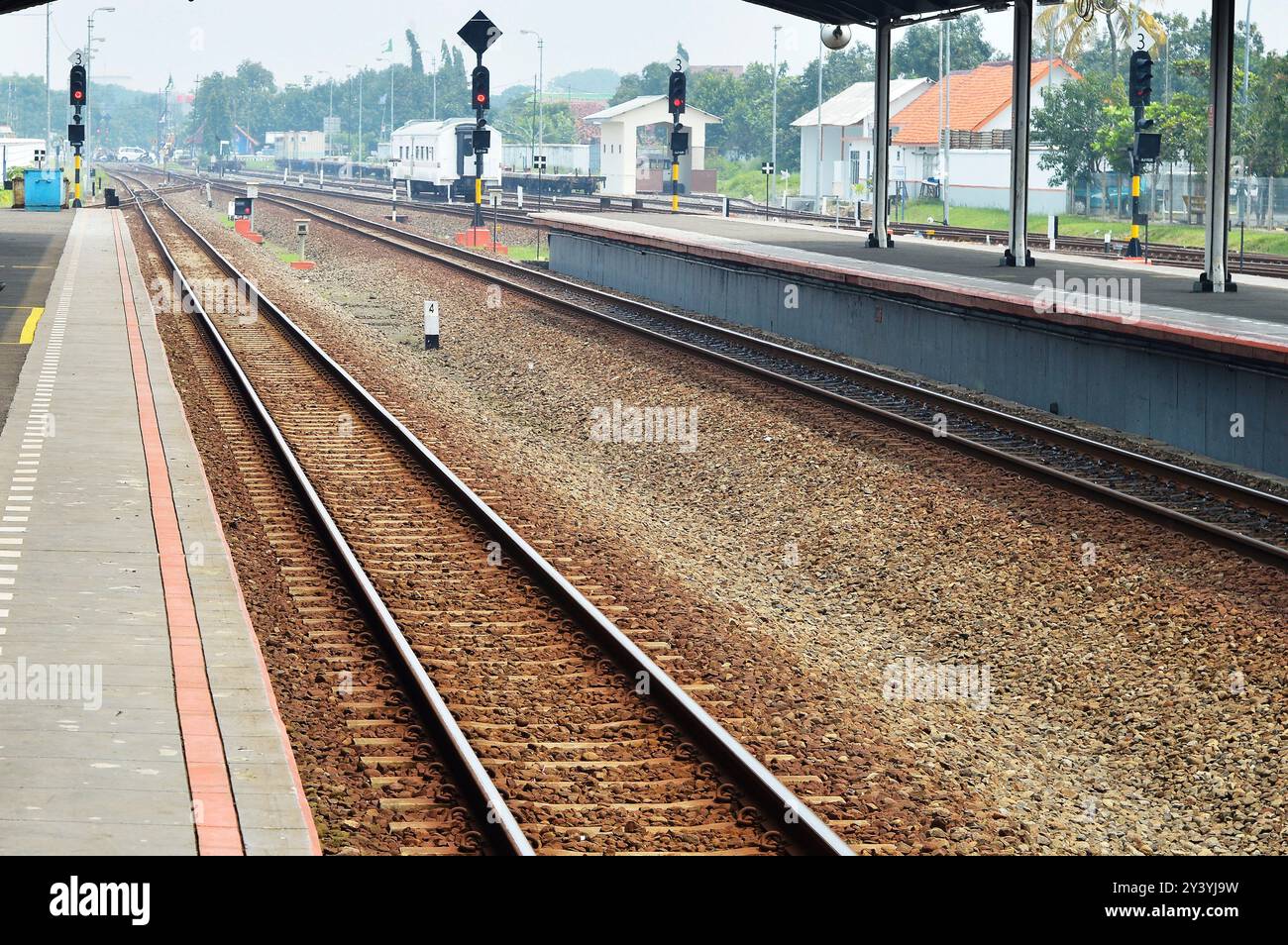two empty railways at a railway station and a platform on each side ...