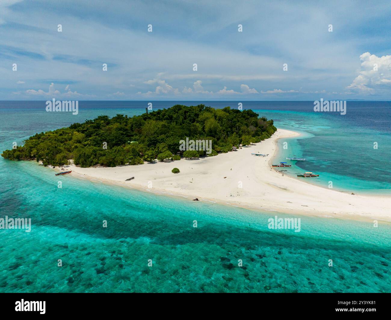 Flying over the white beach with turquoise water in Mantigue Island ...