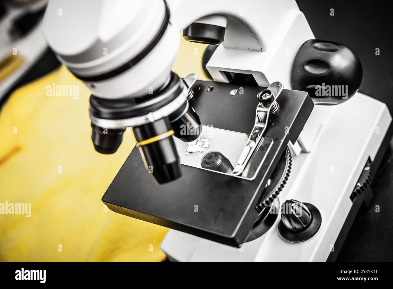 Laboratory microscope positioned above a prepared slide, highlighting ...