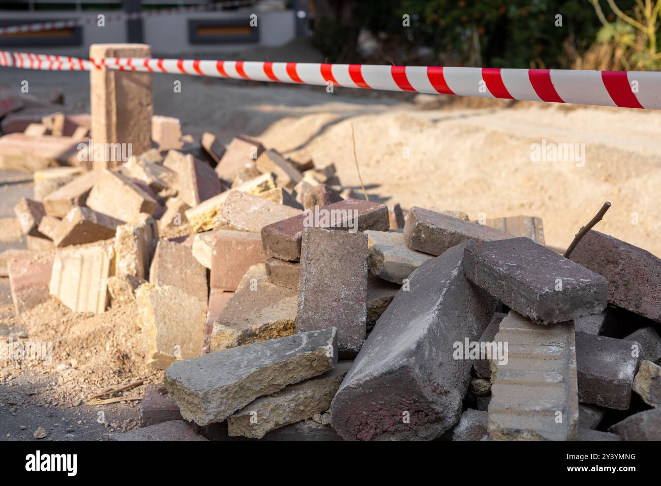 Construction site with a pile of bricks and caution tape marking the ...