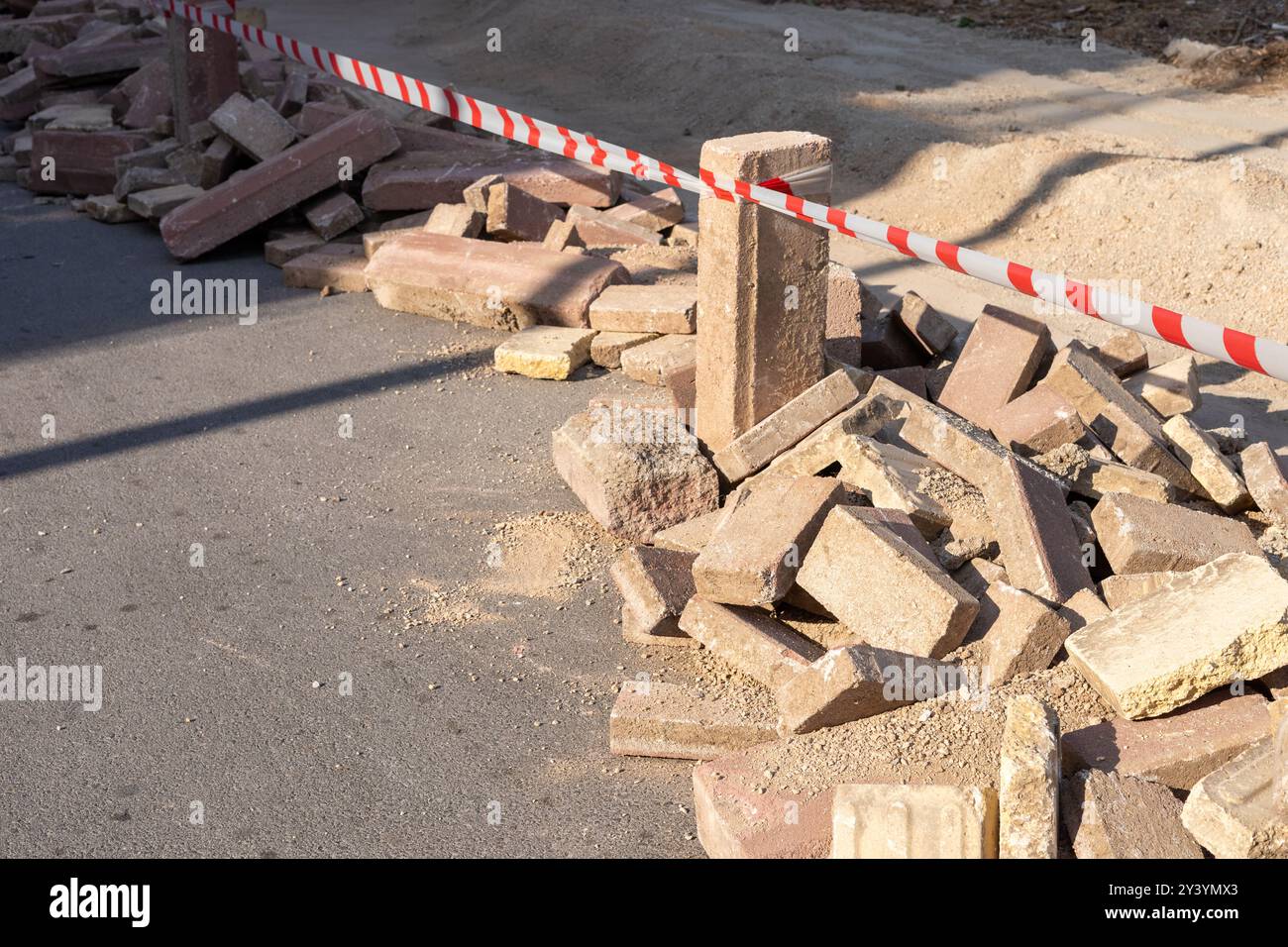 Construction site with a pile of bricks and caution tape marking the ...