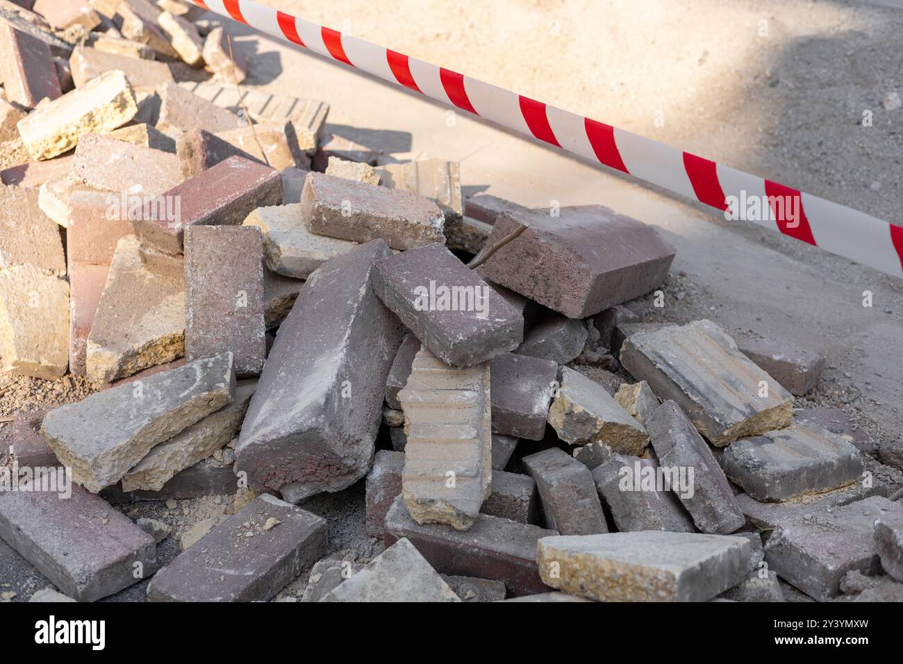 Construction site with a pile of bricks and caution tape marking the ...
