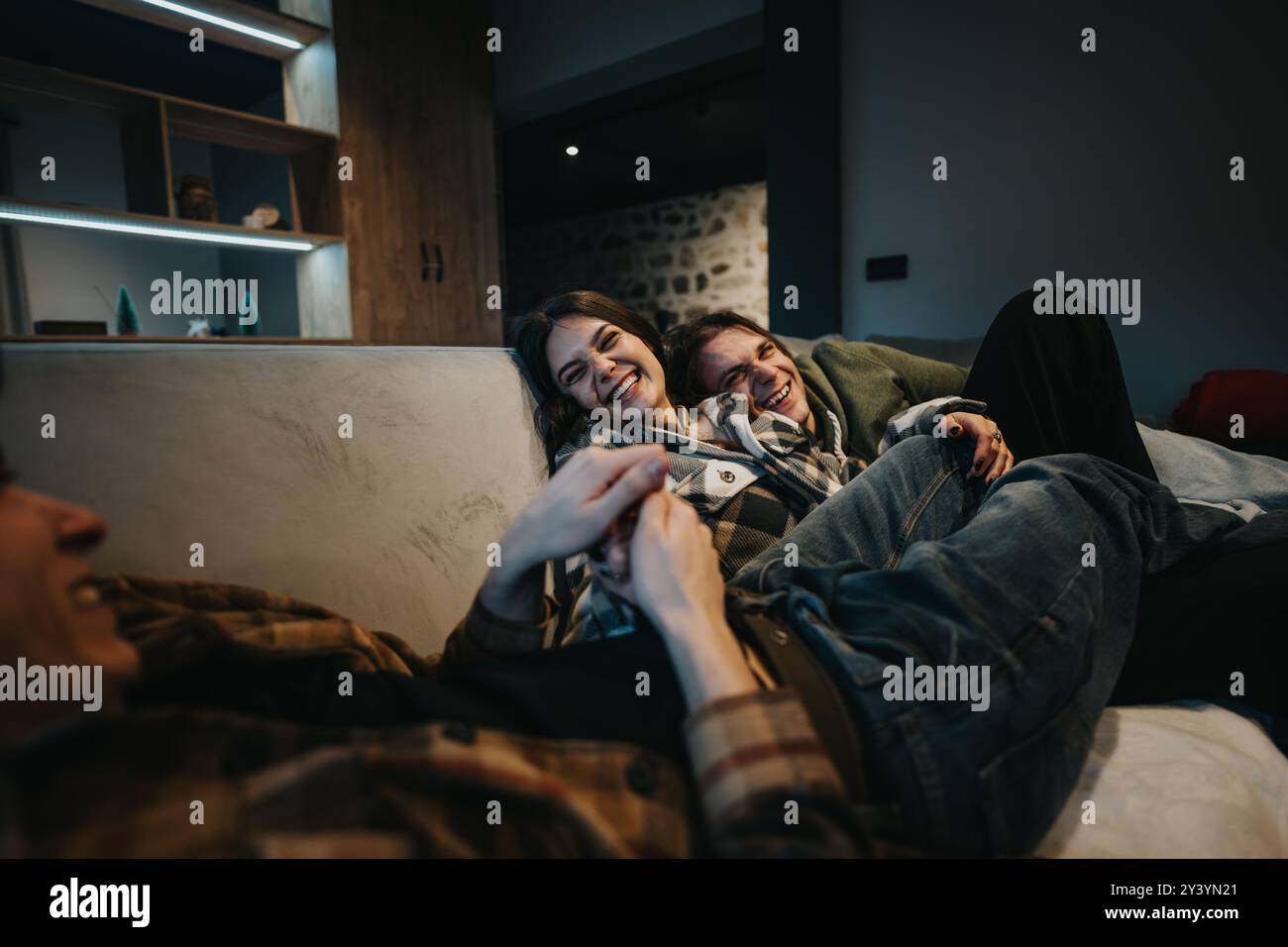 Two friends laughing and relaxing on a cozy sofa in a stylish living ...