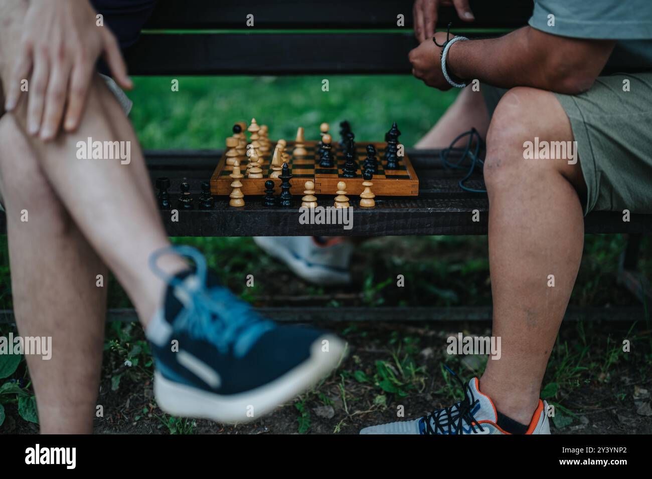 Two friends playing chess on a park bench outdoors Stock Photo - Alamy