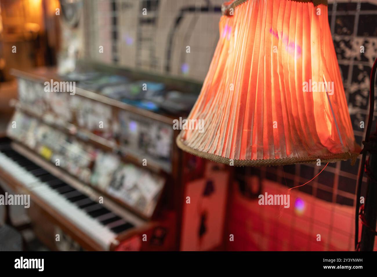 Vintage and Worn-Out Piano Covered in Stickers in a Dimly Lit Room ...
