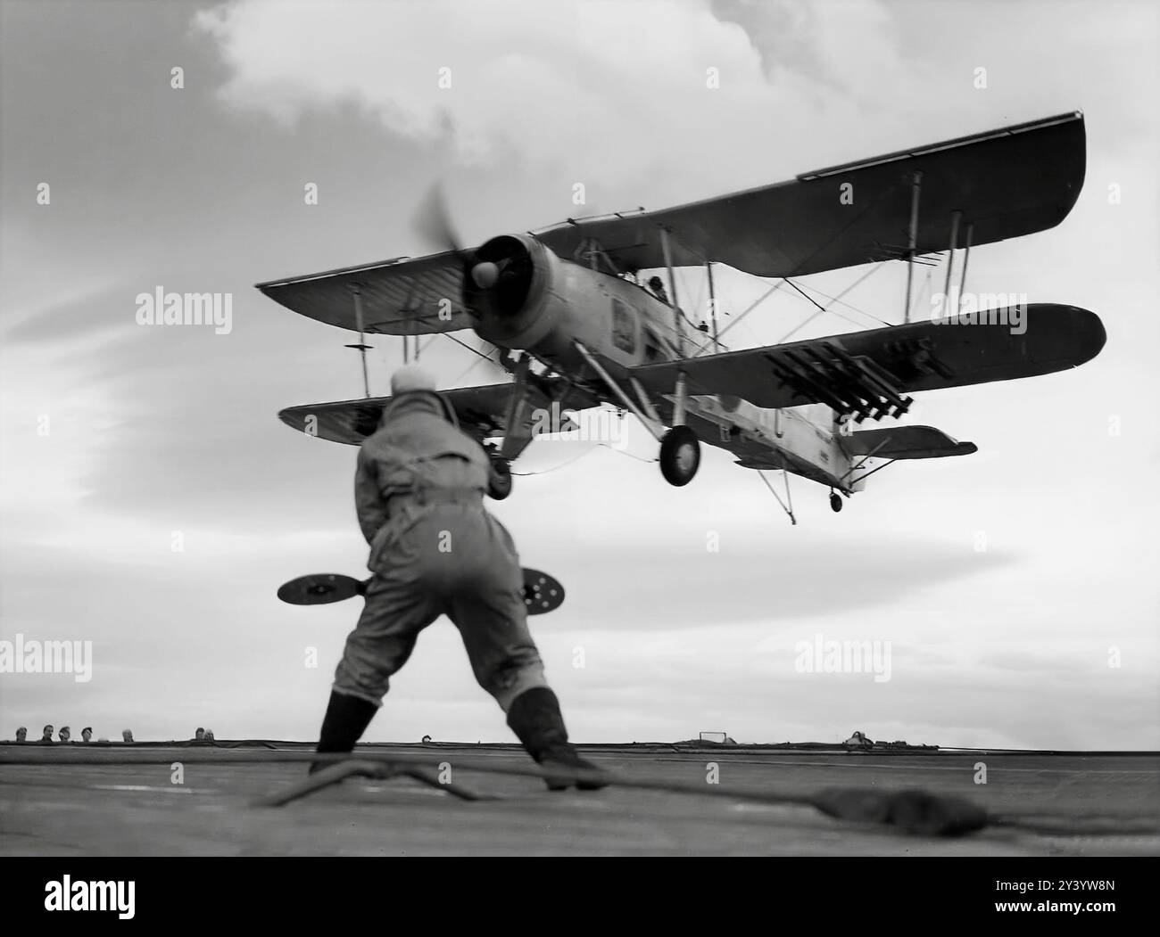 A batsman signalling down a Fairey Swordfish, a torpedo bomber and ...