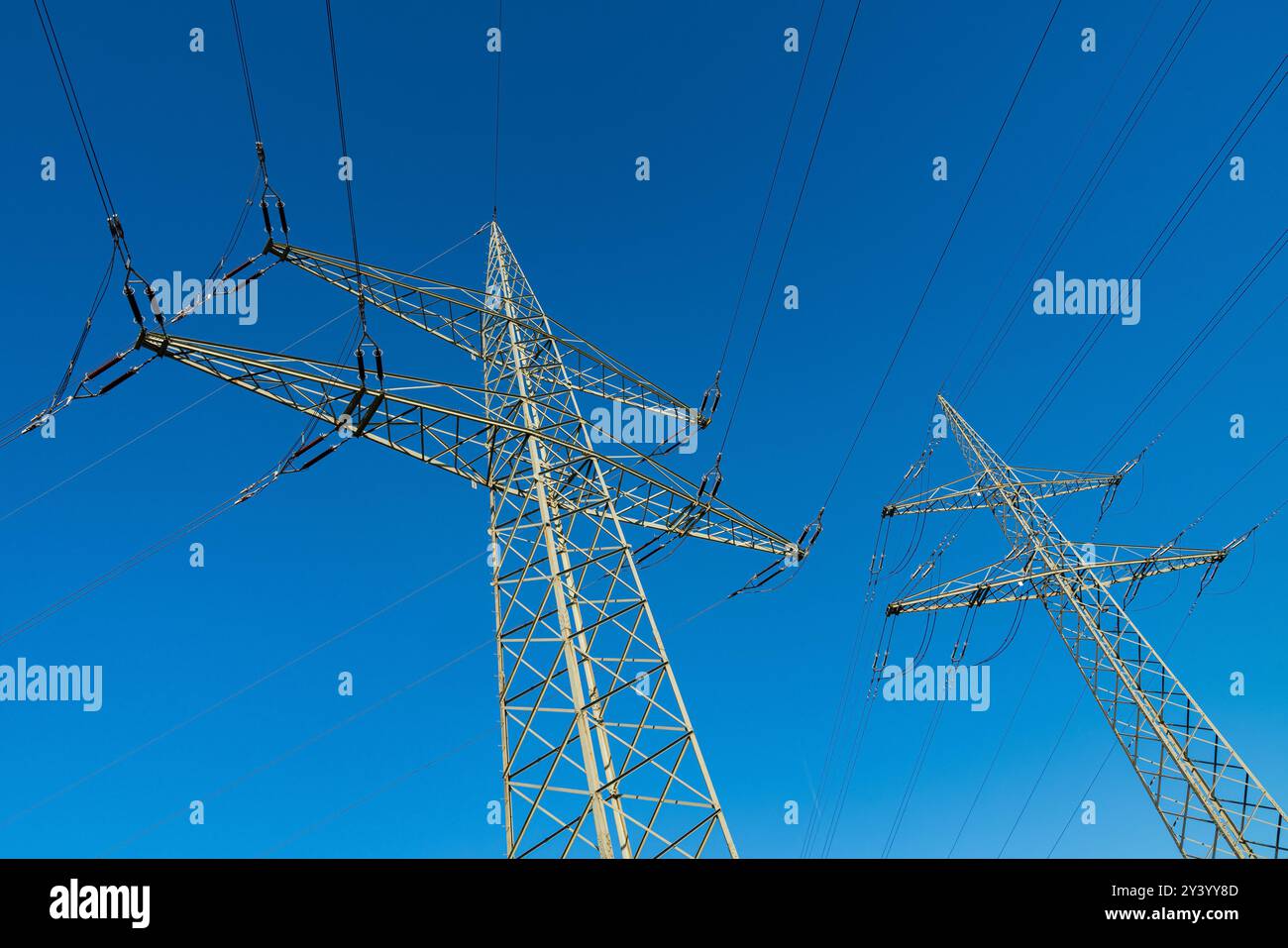 Powerful electricity transmission towers stand tall in the landscape ...