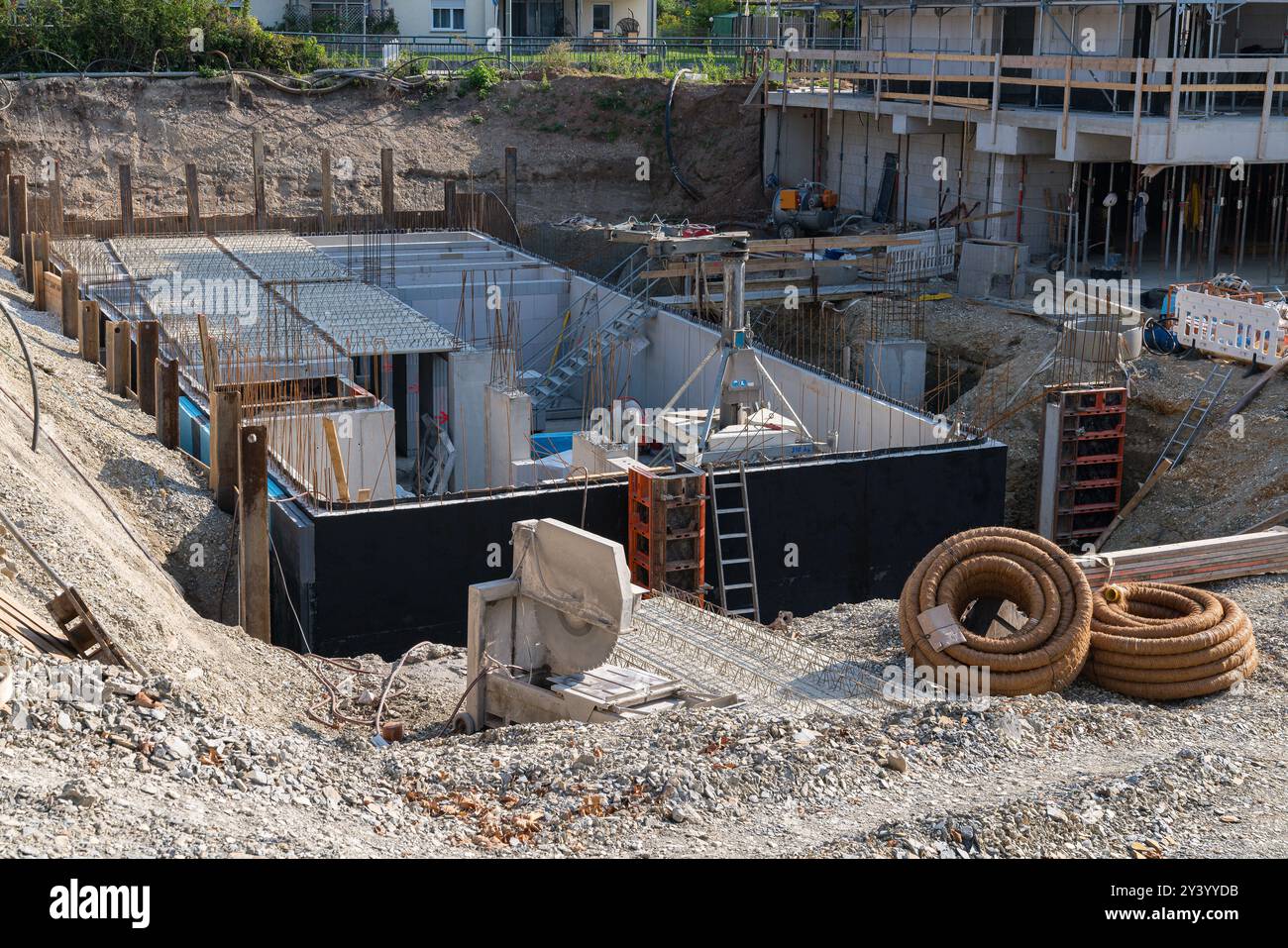 Work is underway at a construction site where a building foundation is ...