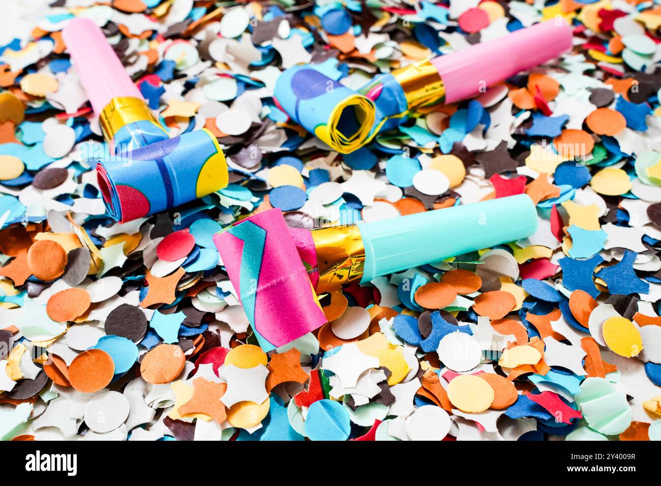 Party horns on colorful confetti stillife Stock Photo - Alamy