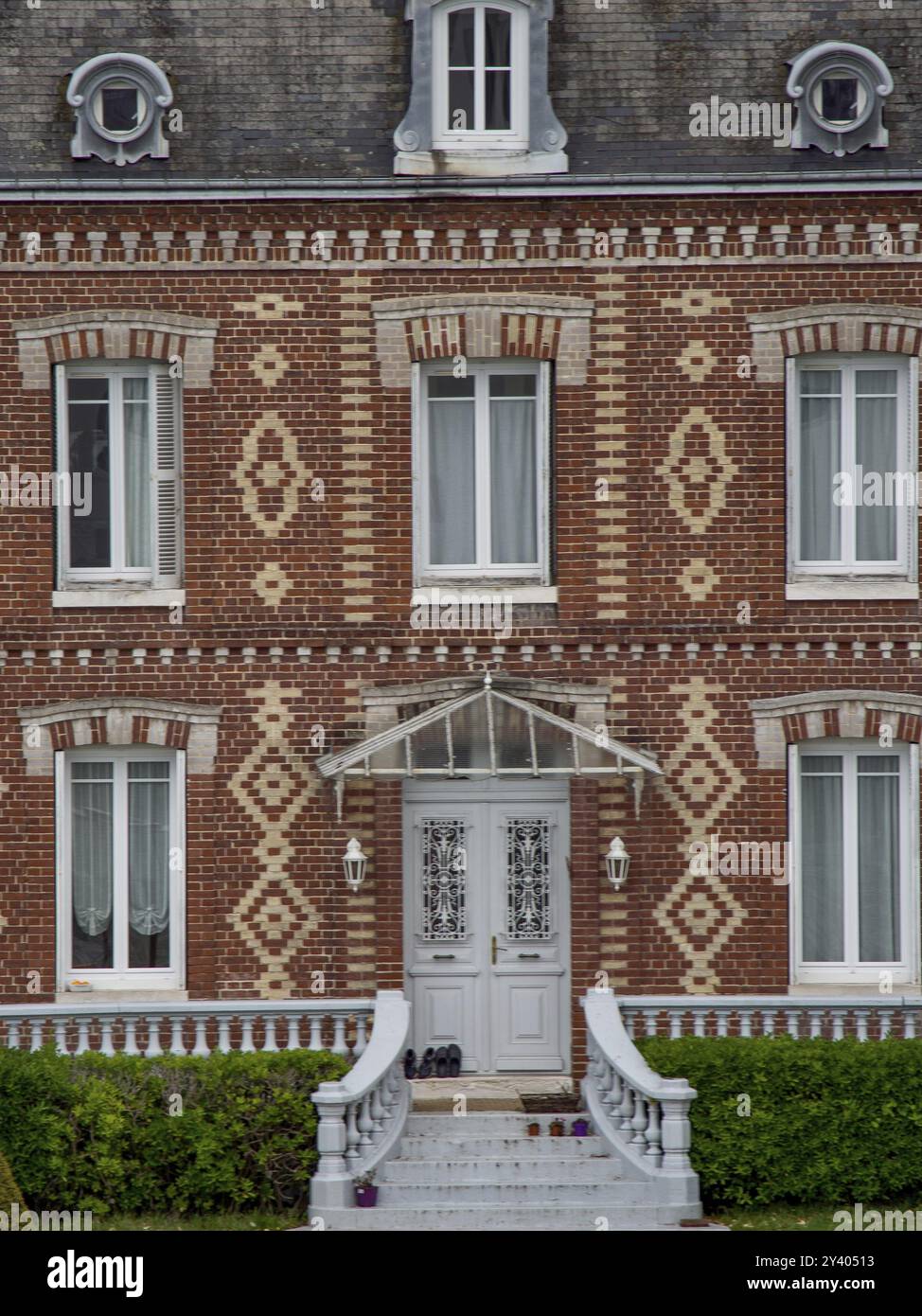 A historic brick building with symmetrical windows and a central front ...