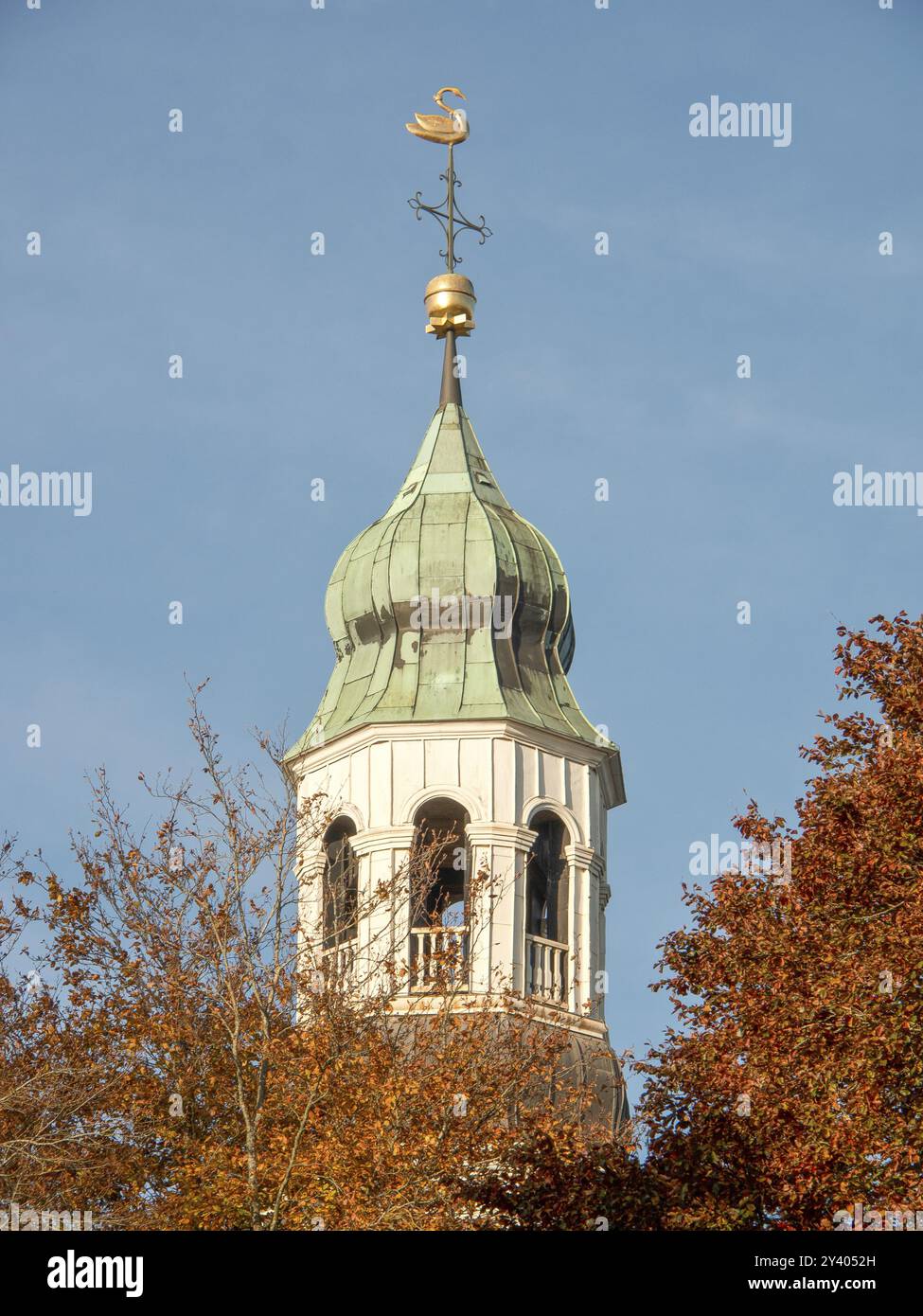 White church tower with copper roof and golden weather vane in autumn ...