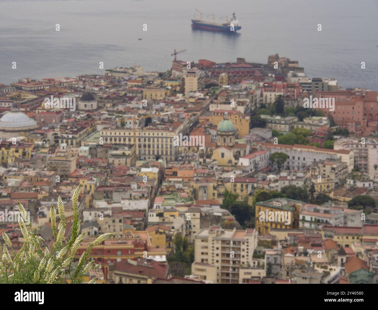Bird's eye view of a city on the coast with a ship on the water, naples ...