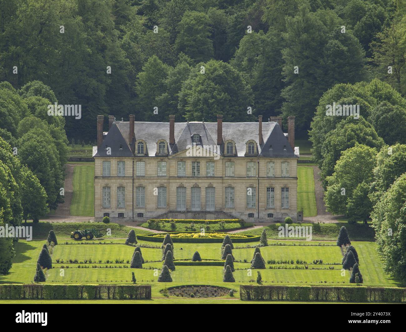 Historic castle with manicured garden in the middle of a dense forest ...
