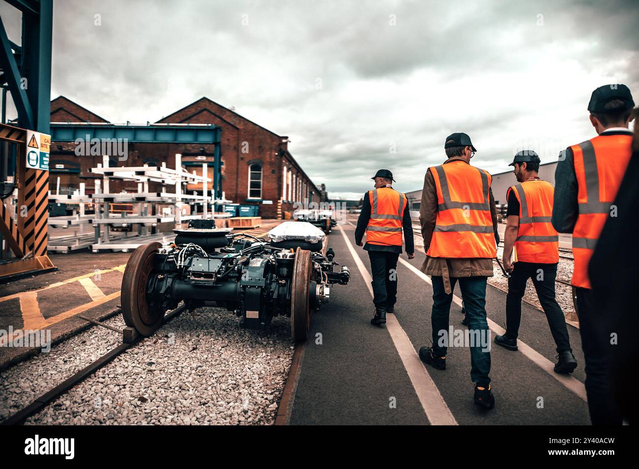 Group of workers visitor in orange safety vests walking through an ...