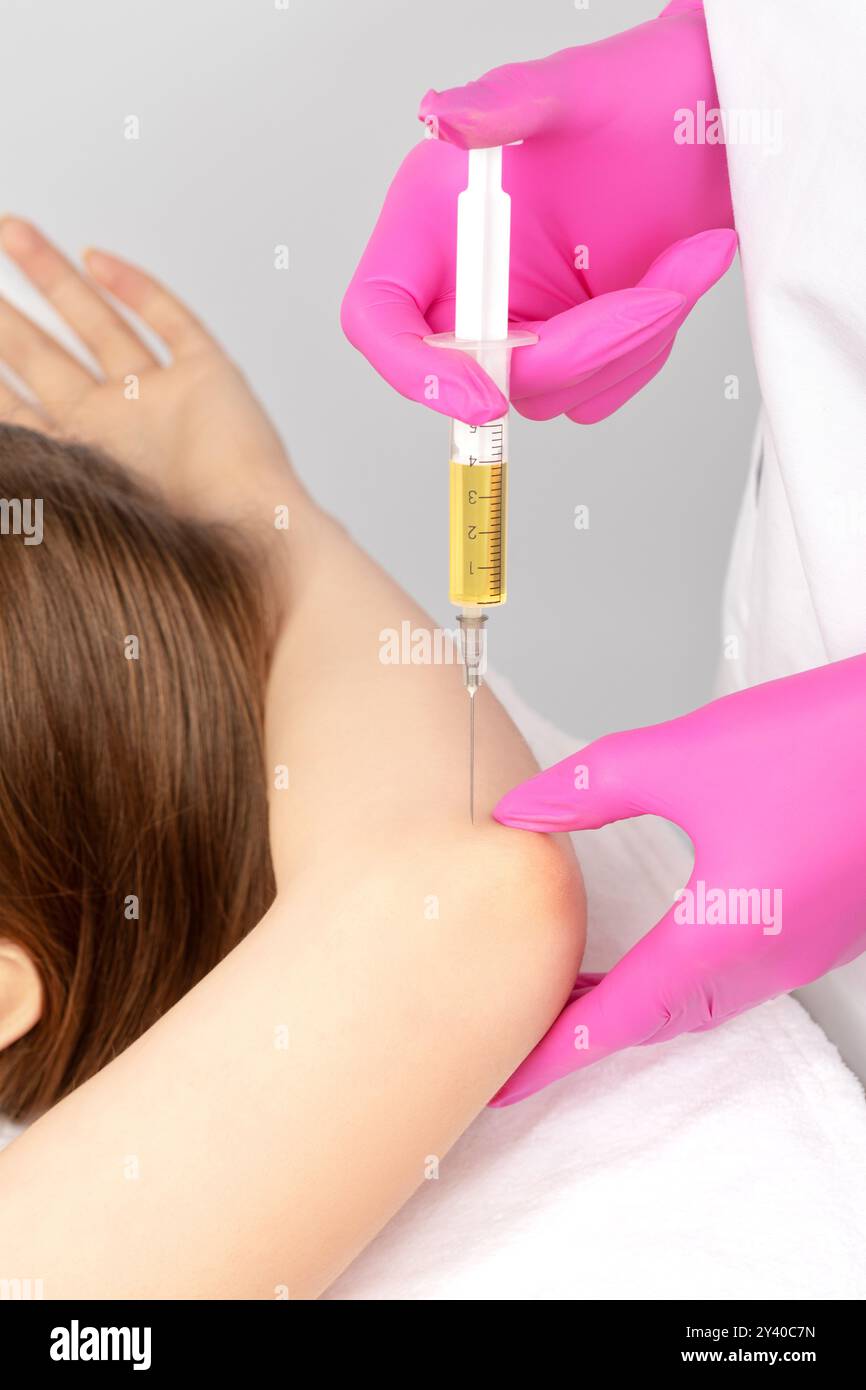 Doctor doing stem cell therapy on a patient's elbow after the injury. Treating knee pain with ...