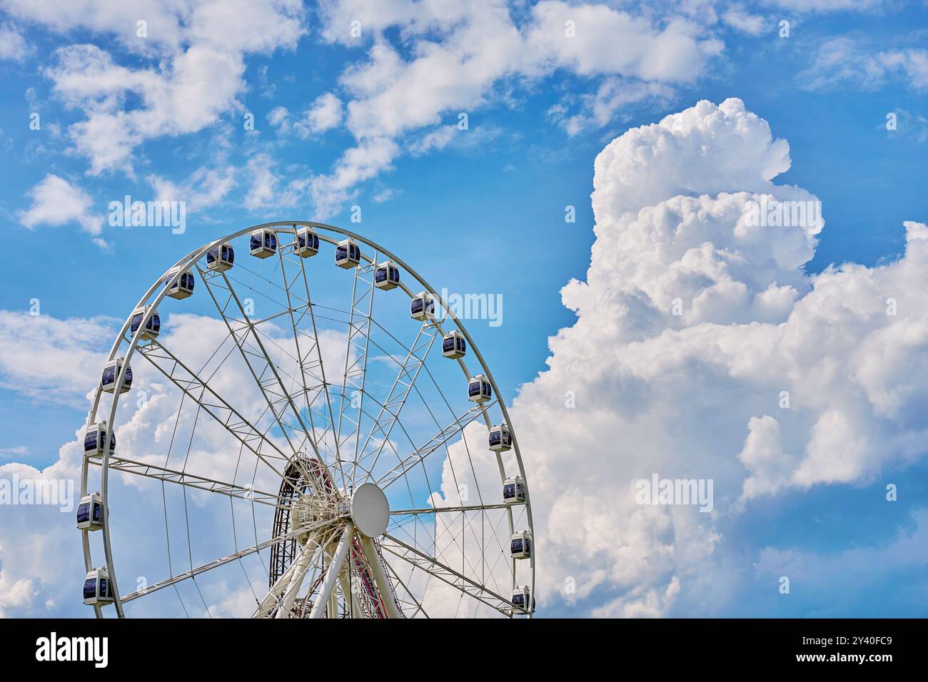 Ferris wheel with cabins set against blue sky. Leisure and amusement ...