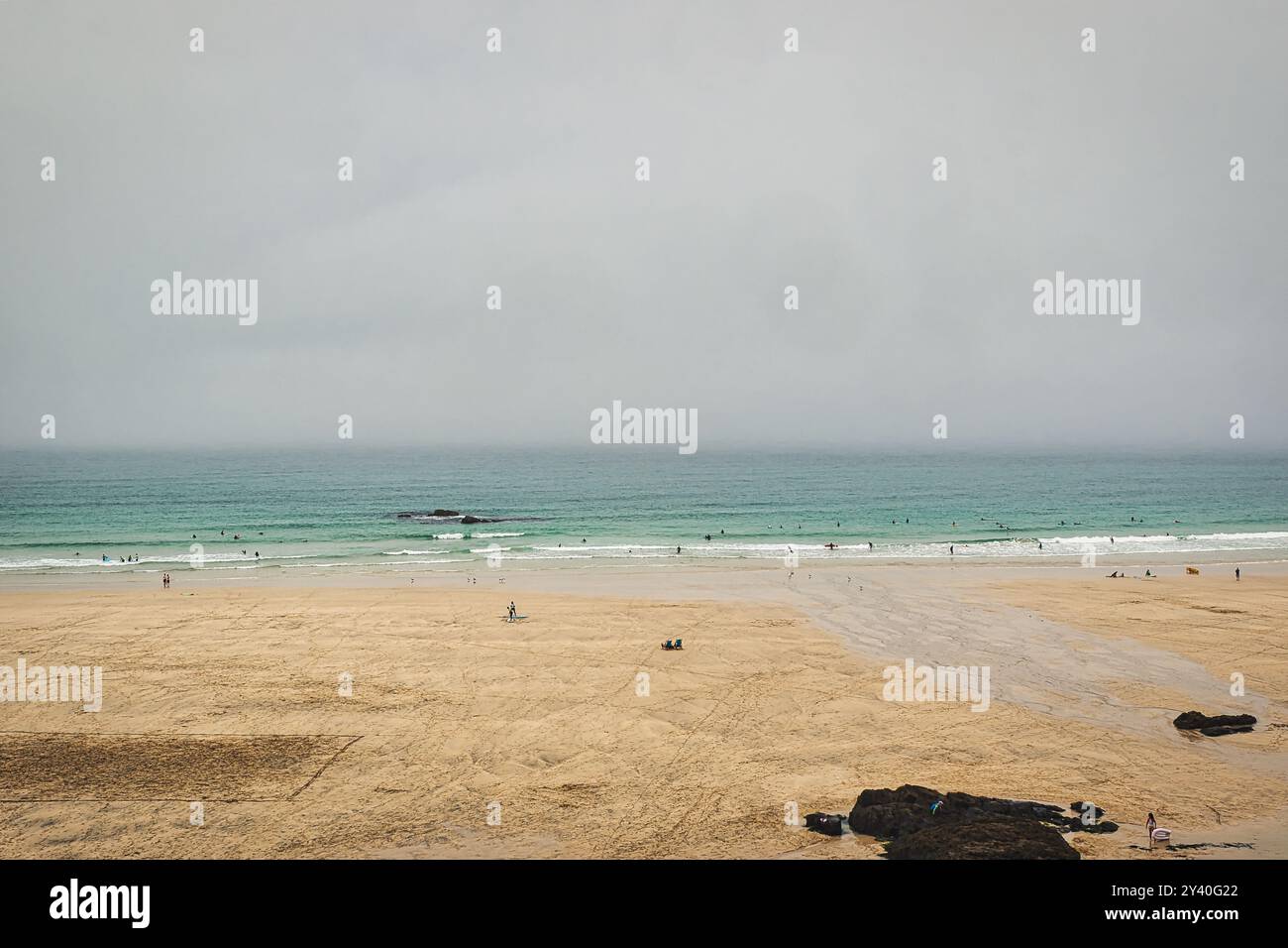 A serene beach scene with gentle waves lapping at the shore. The sky is ...