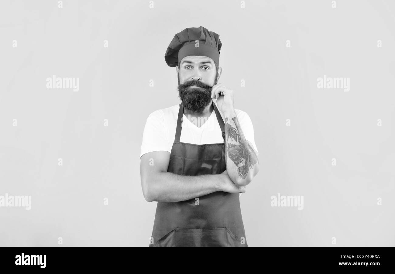 Man in red apron and toque twirling moustache with puzzled look yellow ...