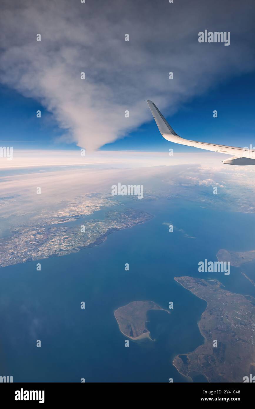 Airplane flying over color sky clouds during scenic sunset or sunrise ...