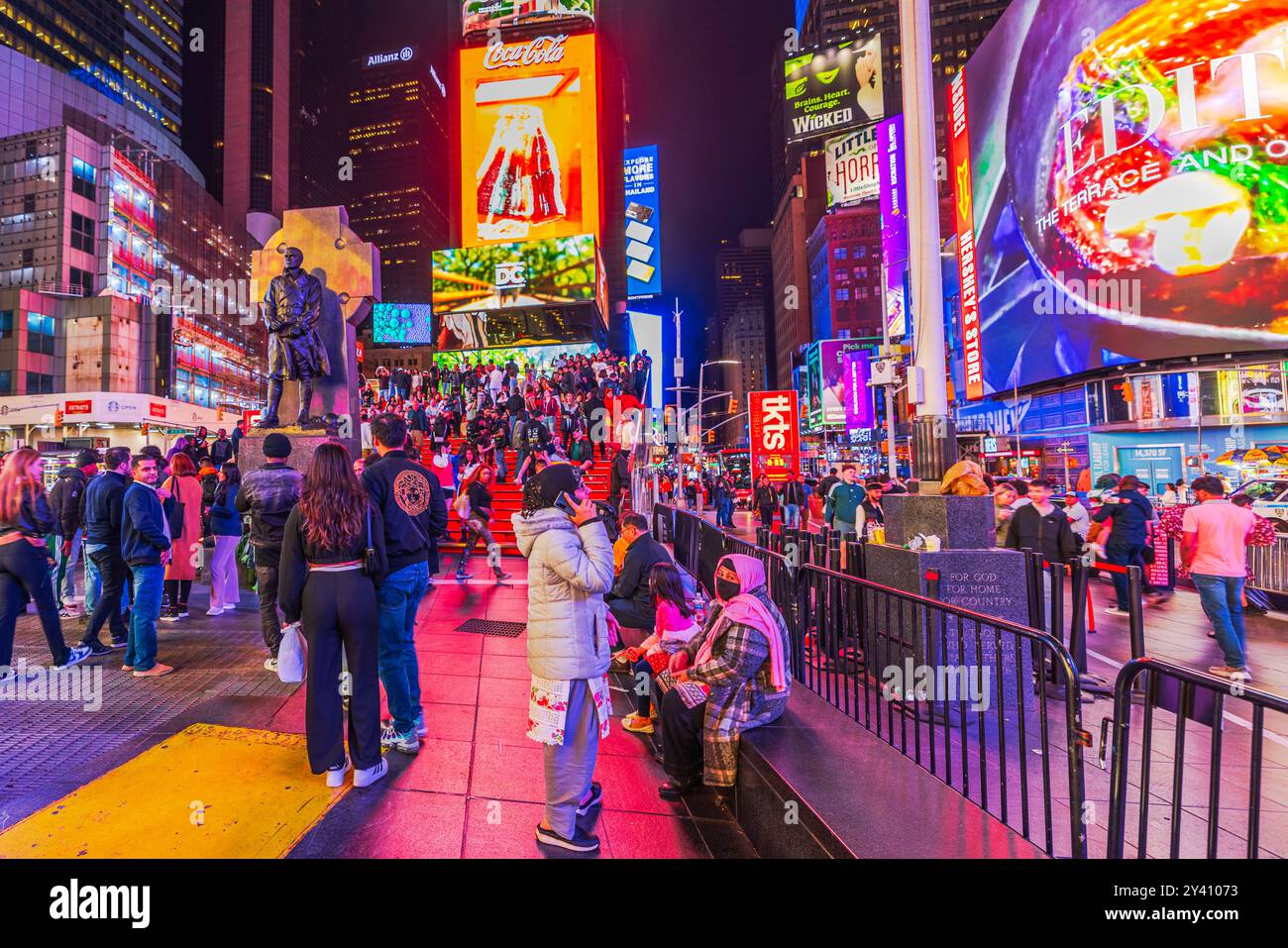 Night view of Times Square with pedestrians, red stair, and skyscrapers ...