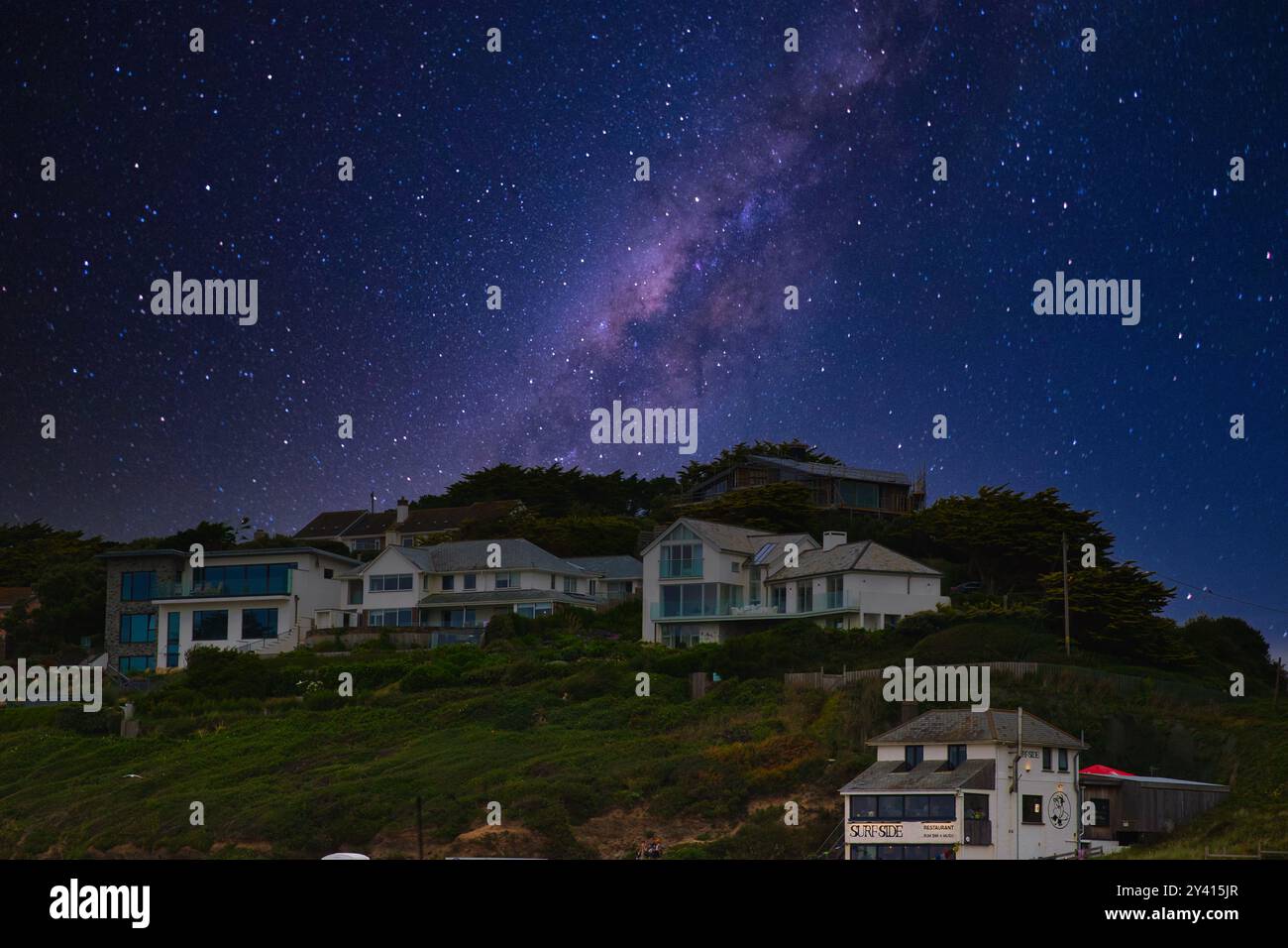 A picturesque coastal scene featuring houses on a hillside under a ...