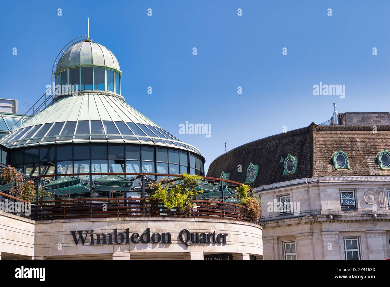 A bright blue sky over the Wimbledon Quarter, showcasing a modern glass ...