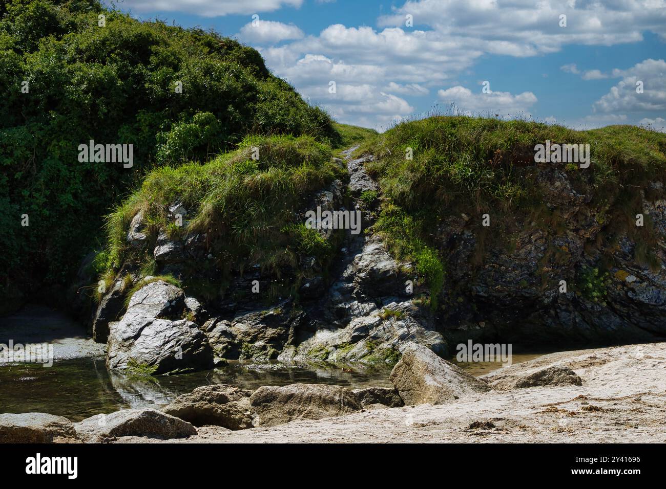 A serene coastal landscape featuring rocky formations and lush greenery ...