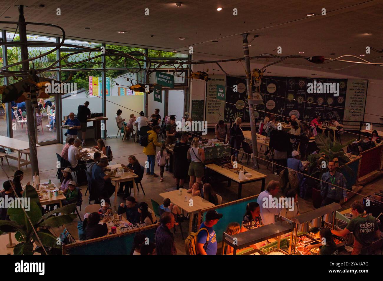 A bustling indoor market or food hall filled with people dining and ...