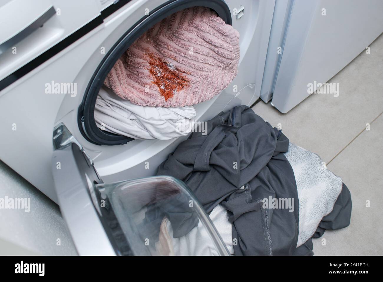 Dirty cloth with a red spot in a washing machine Stock Photo - Alamy