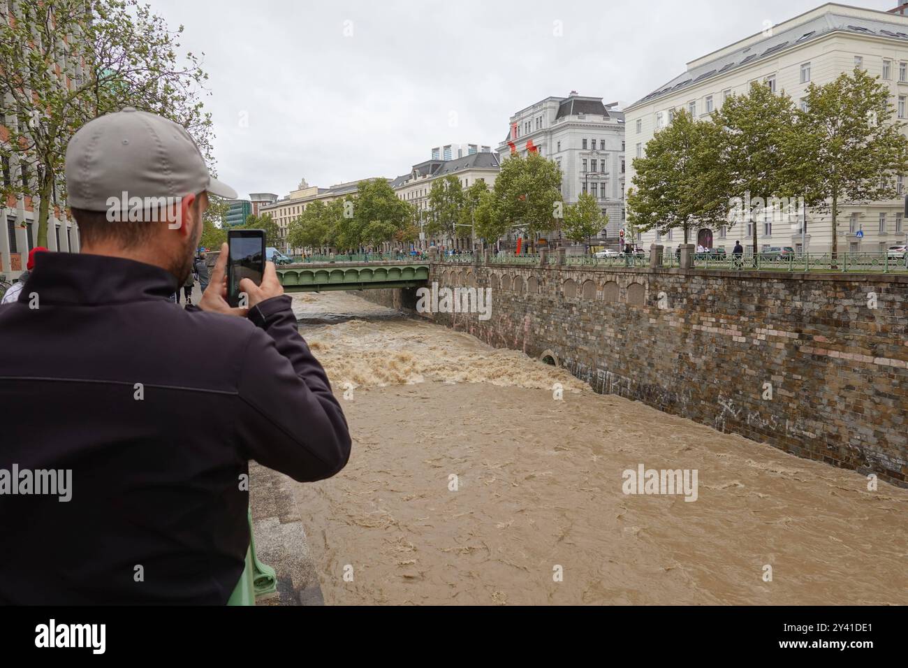 Wien, ein Mann fotografiert das Wienfluss-Hochwasser am 15.9.2024 ...