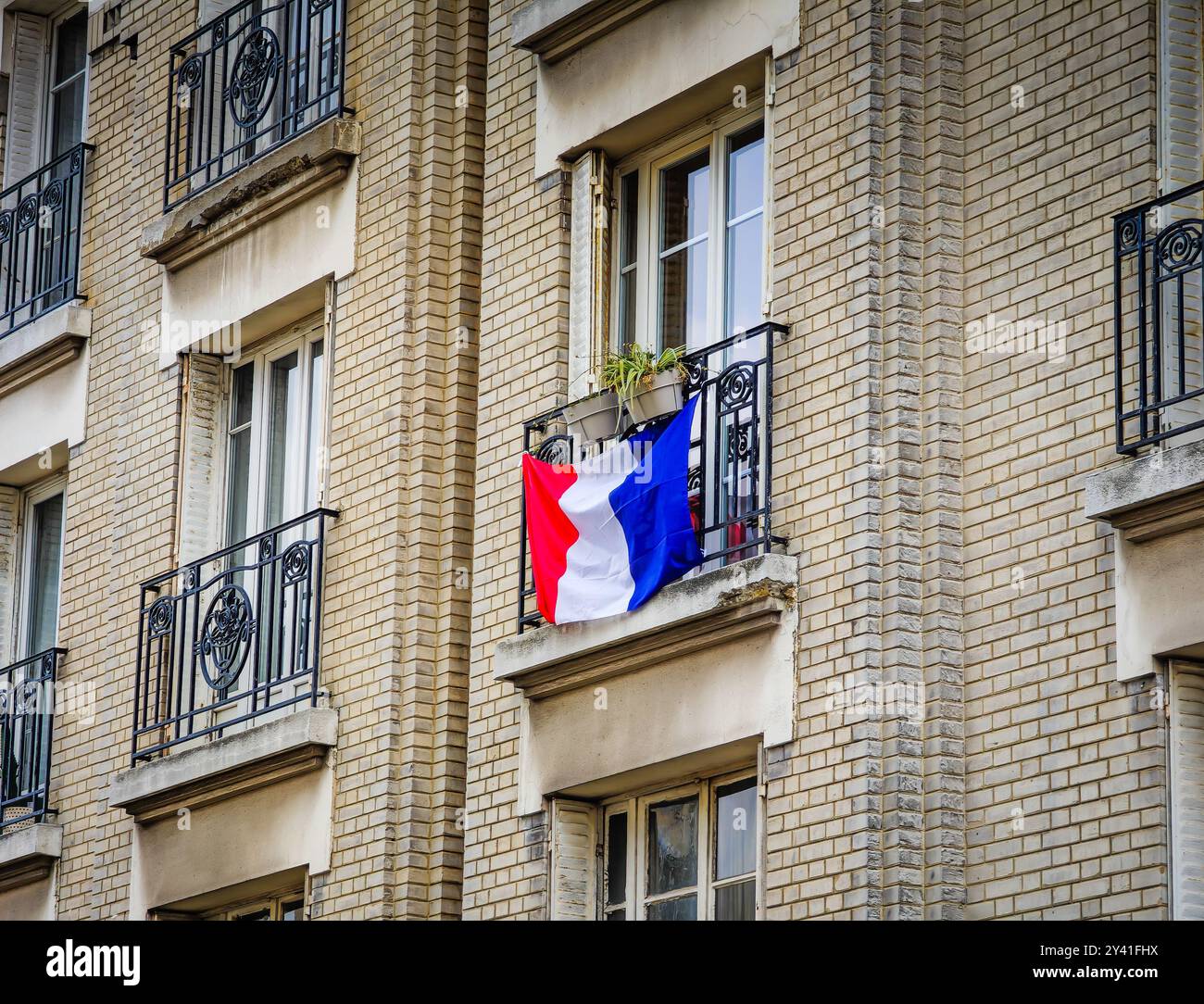 Typical Parisian building facade with French flag on balcony. Typical ...